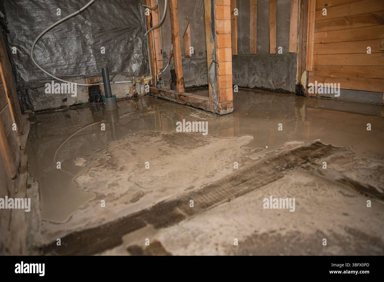 Wet concrete floor inside wooden structure during construction or ...