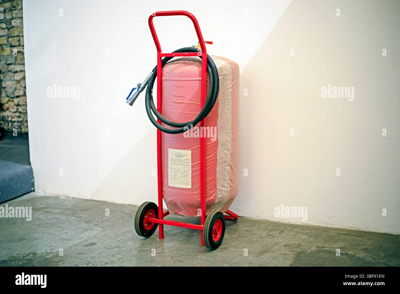 fire extinguisher and wiring in an interior with brickwork with ...