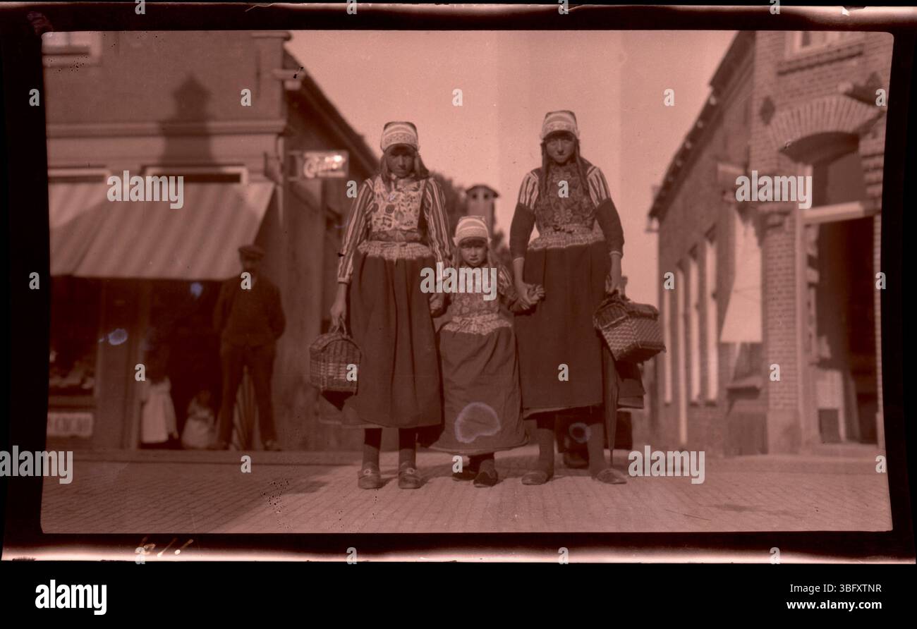 In 1913, three Dutch girls in traditional attire pose for a photograph ...