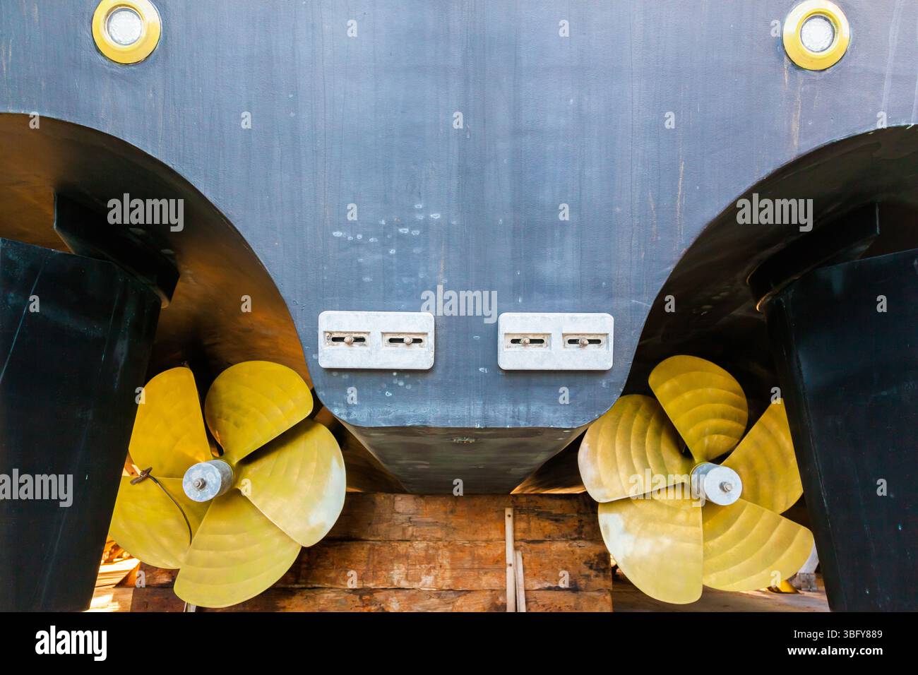 The back of a large motor yacht, standing on wooden blocks in a dry ...