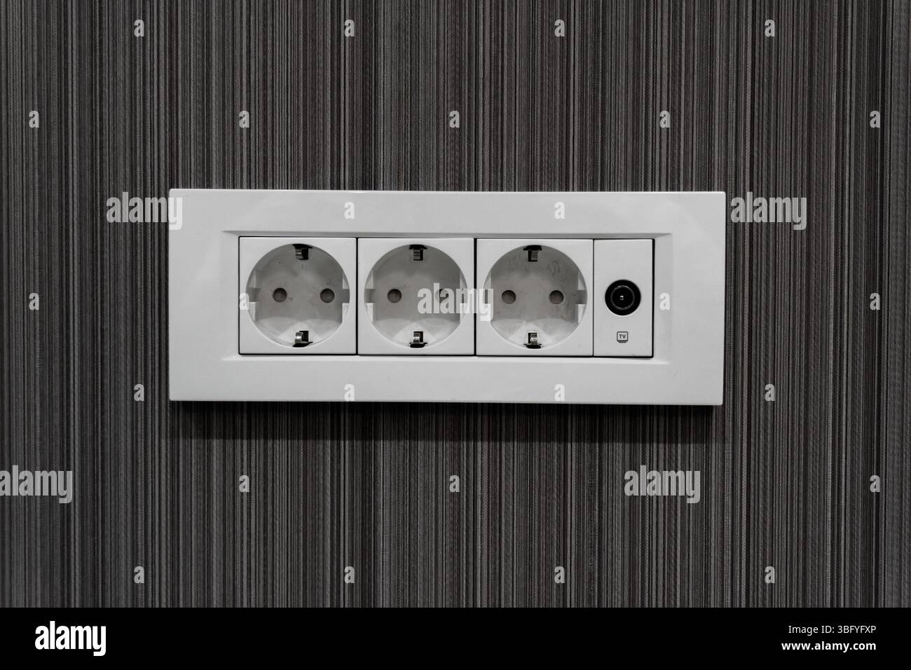 Close-up of a triple European-style electrical power outlet installed ...