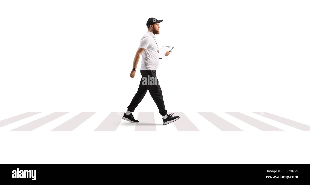 Full length profile shot of a PE teacher walking at zebra crossing ...