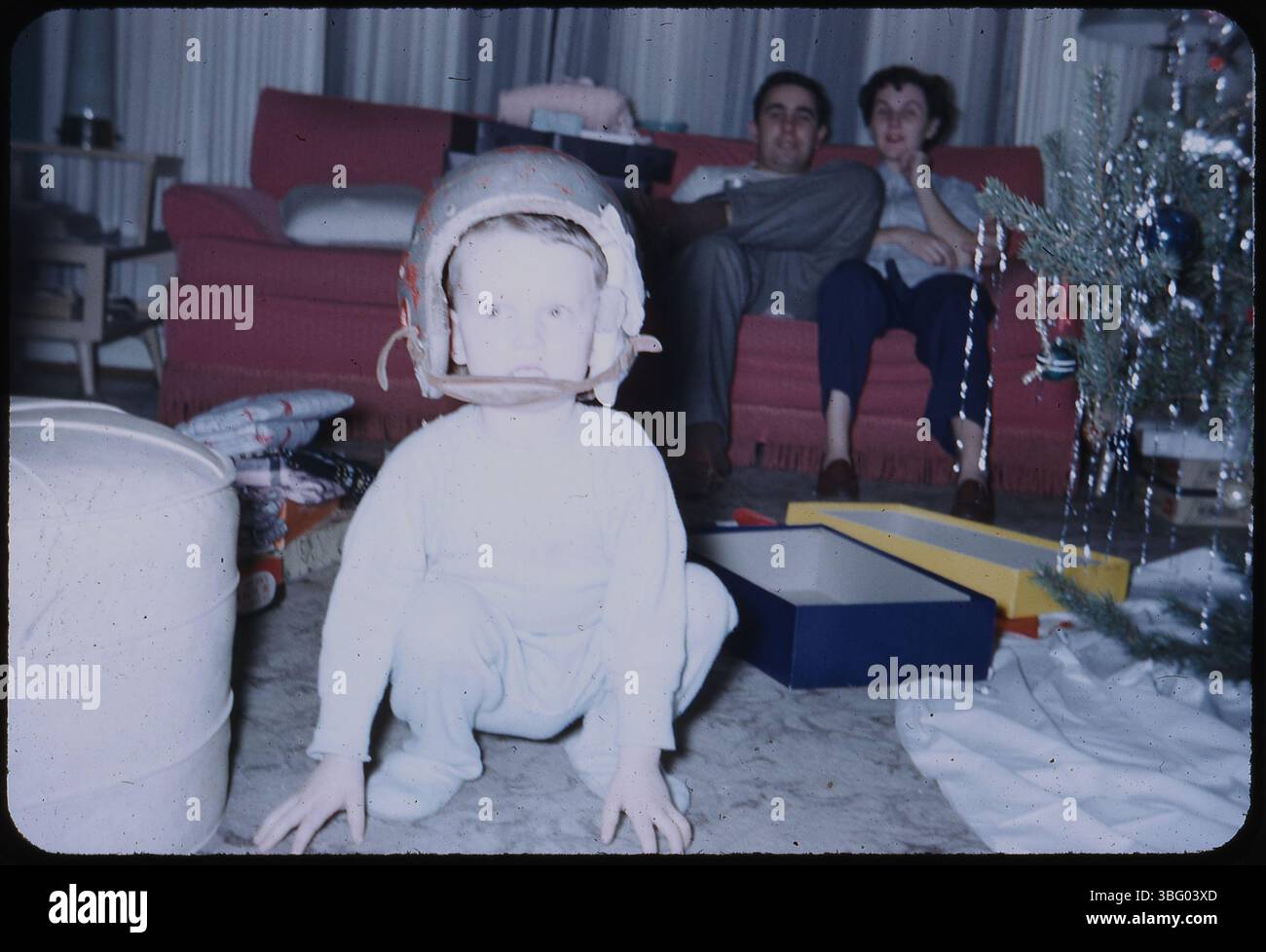 A child wearing a football helmet poses in the Mosbacher family living ...