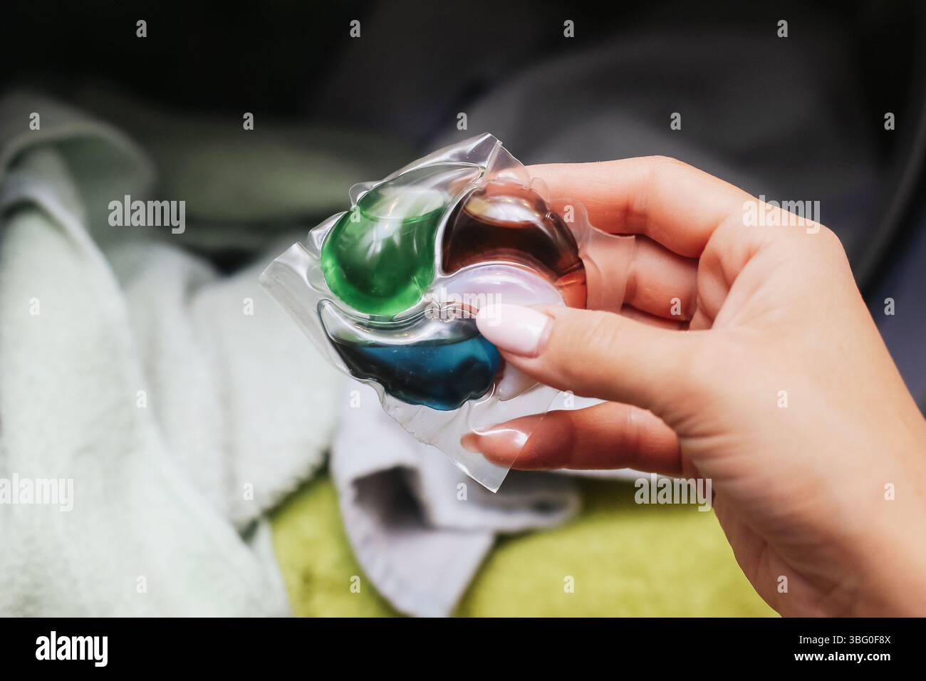 Laundry pod in hand. Colorful capsule close up. Washing machine ...