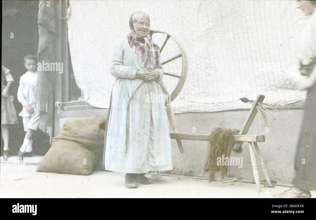 A woman standing by her spinning wheel on High Street in Kenmare ...