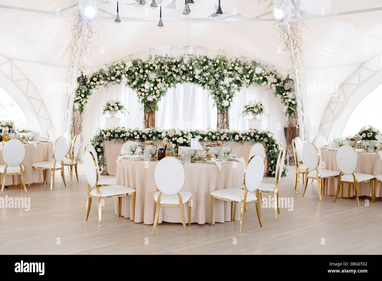 Luxurious wedding setup with round tables, stylish chairs, and ...