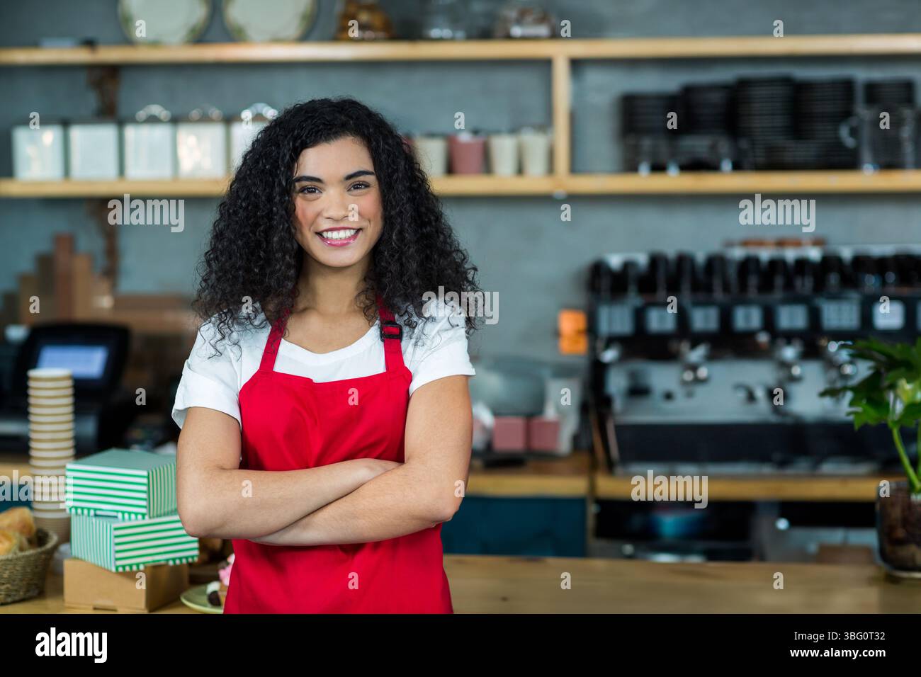 African American woman in red apron operating espresso machine behind ...