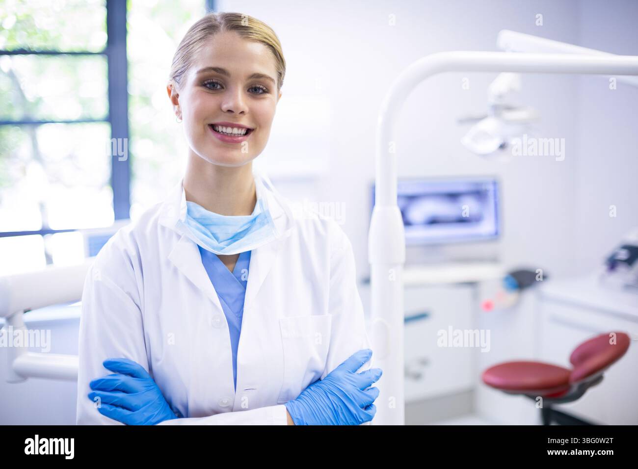 Female dentist standing with arms crossed in dental clinic showing ...