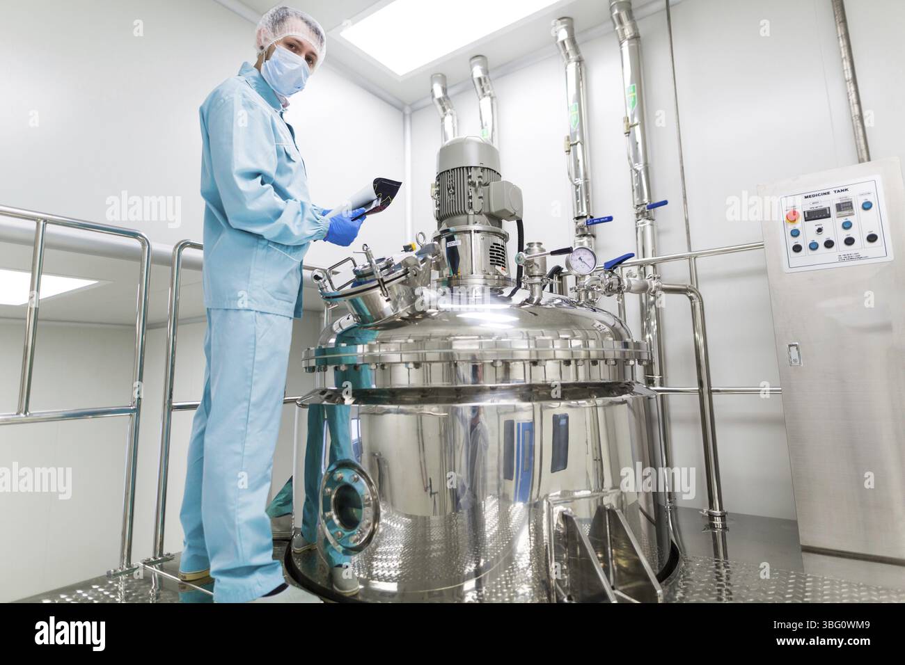 Scientist in blue laboratory suit and gas mask stand in clean room and ...