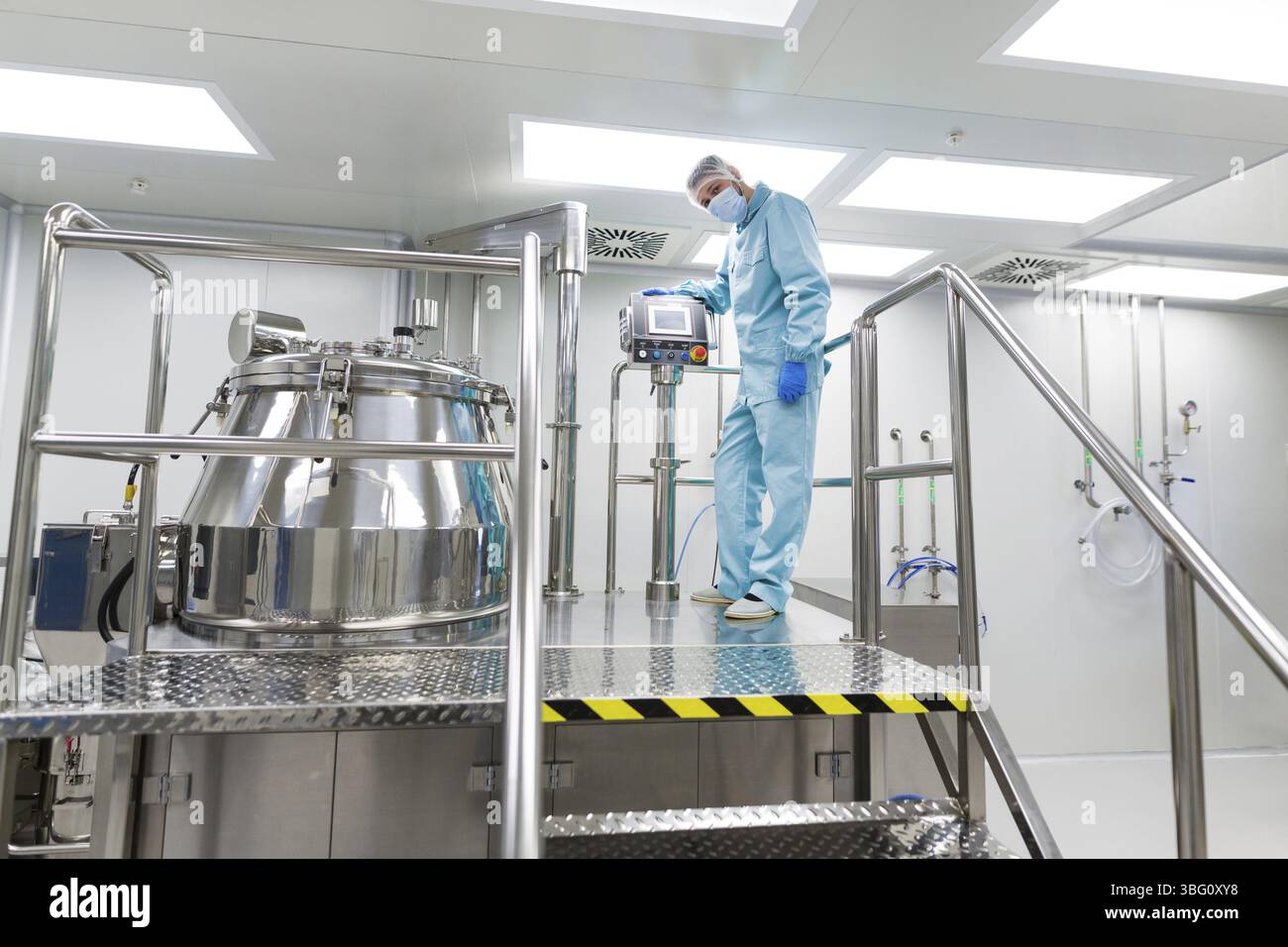 Caucasian scientist in blue lab suit and gloves stand on platform and ...