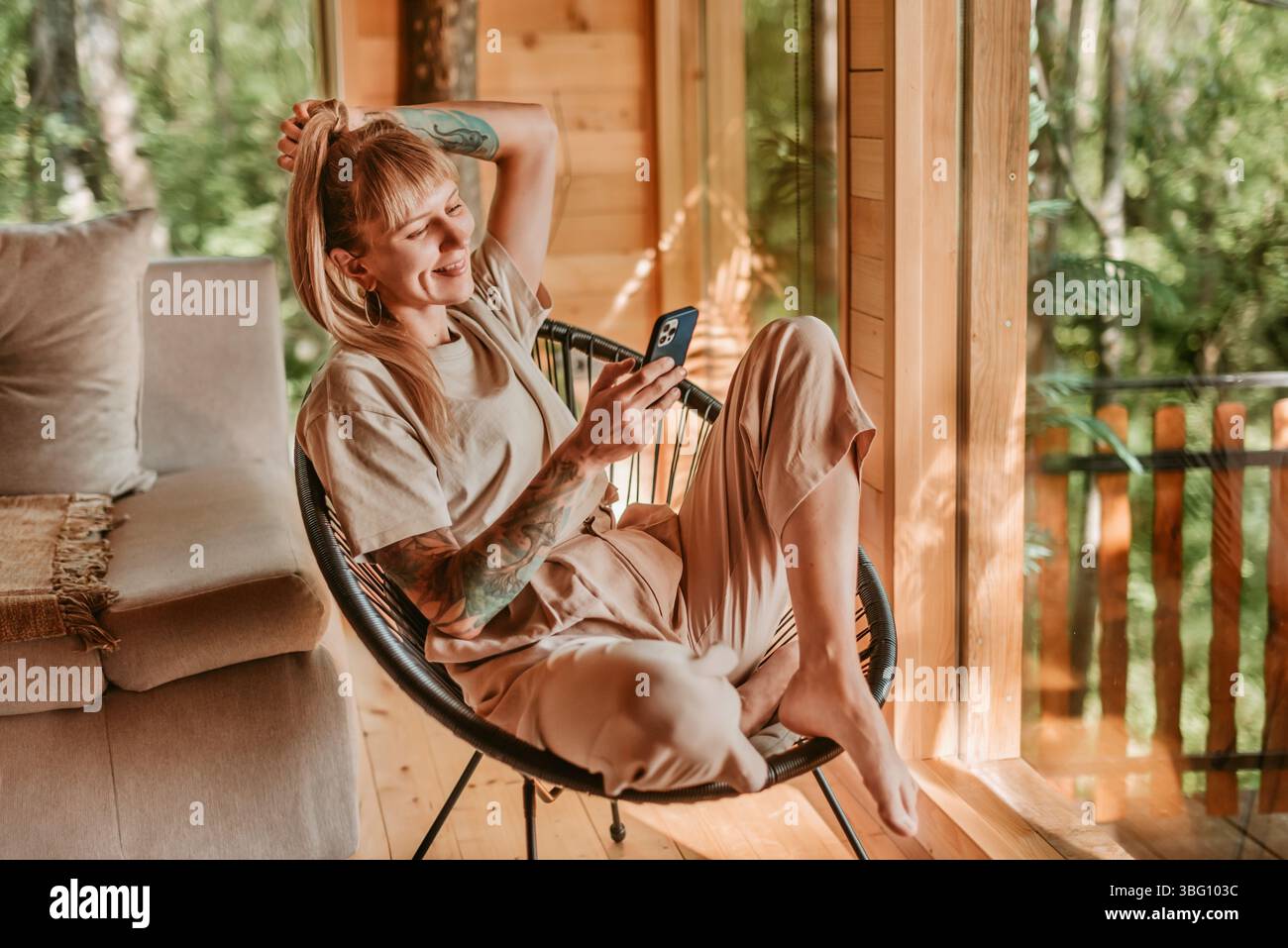 Woman Communicates Using her Phone in Log Cabin Stock Photo - Alamy