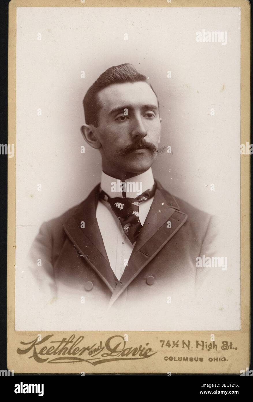 This photograph shows a man with a handlebar moustache, oiled and ...