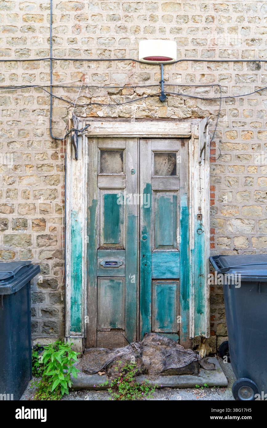 Old distressed weathered wooden door with disintegrating sand bags on ...
