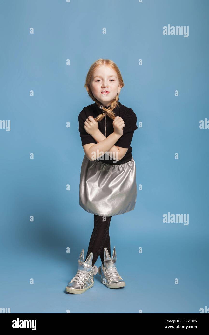 Isolated on blue, red-haired girl in black sweater with zipper, black ...