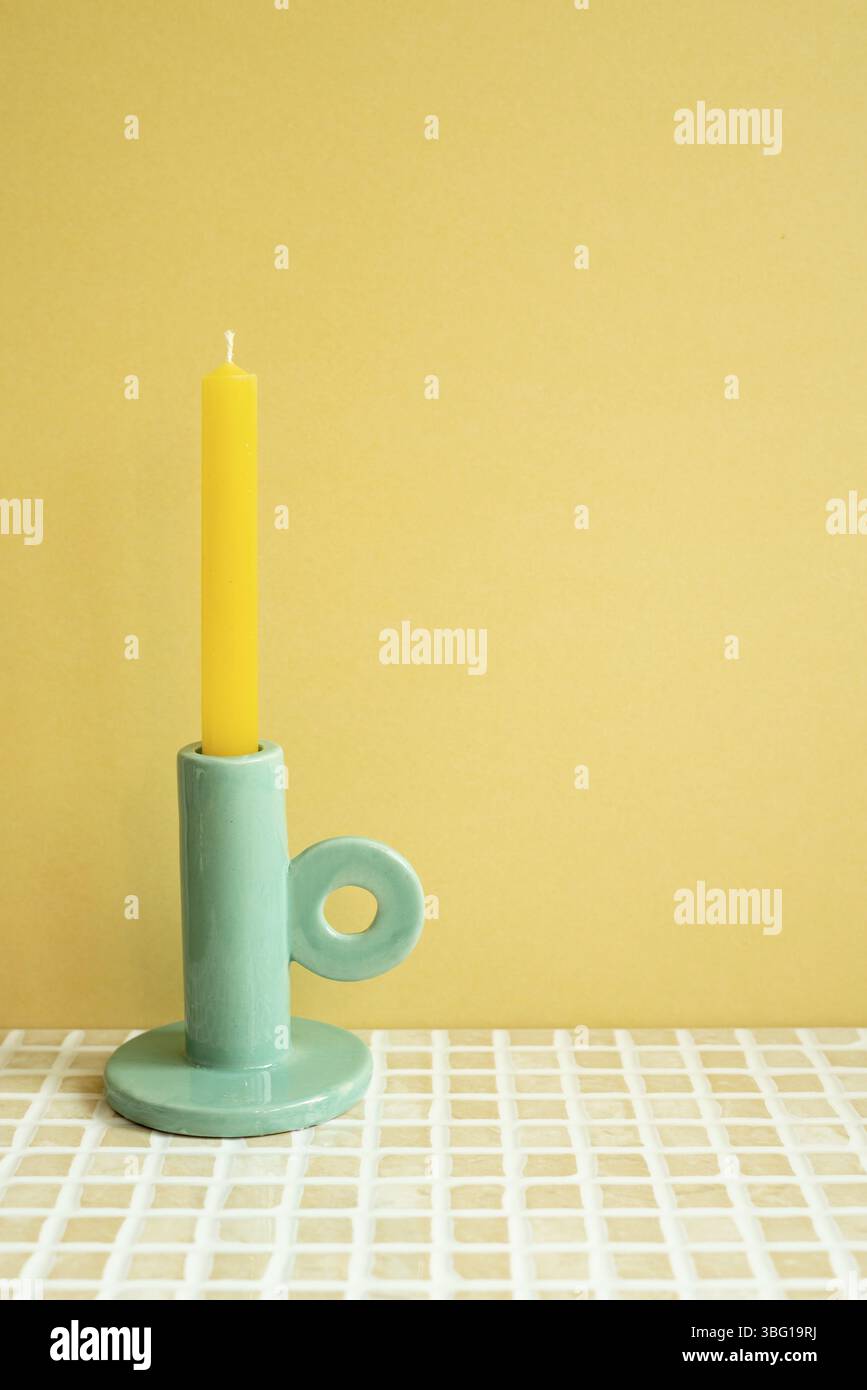 Candle on check tile table. yellow wall background. home interior Stock ...