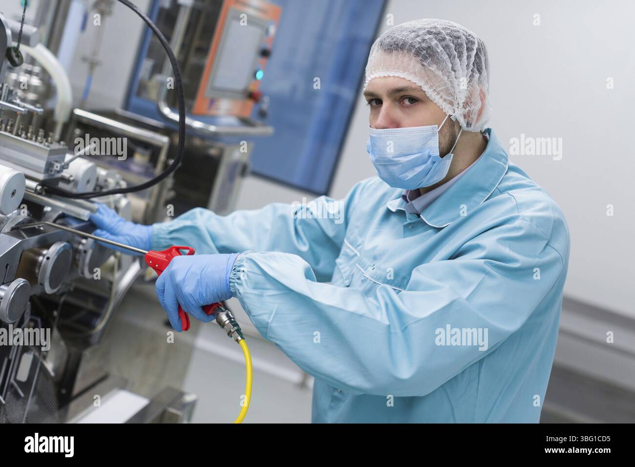 Caucasian scientist in blue lab uniform configure manufacture machine ...