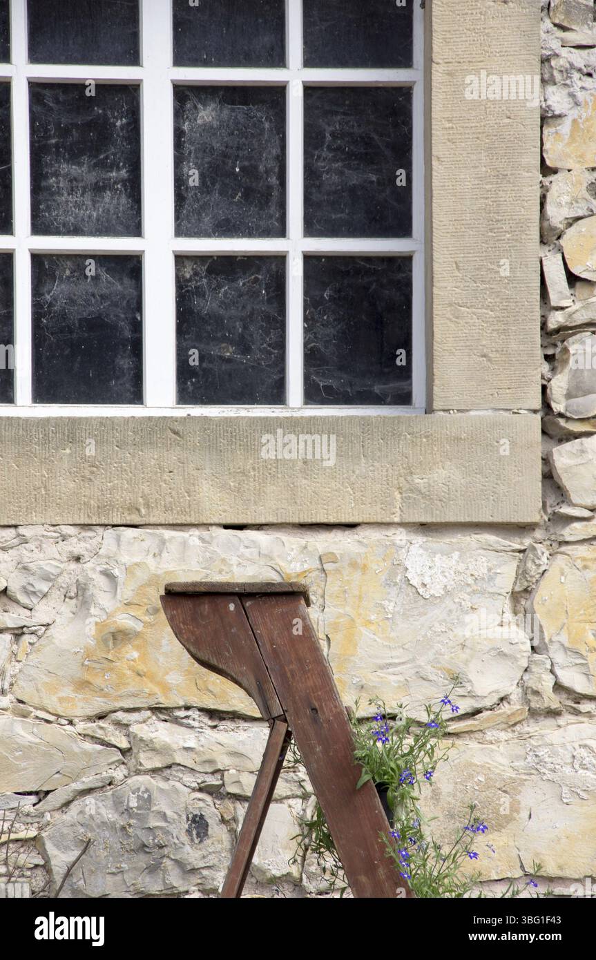 Decorative wooden ladder in front of natural stone wall Stock Photo - Alamy