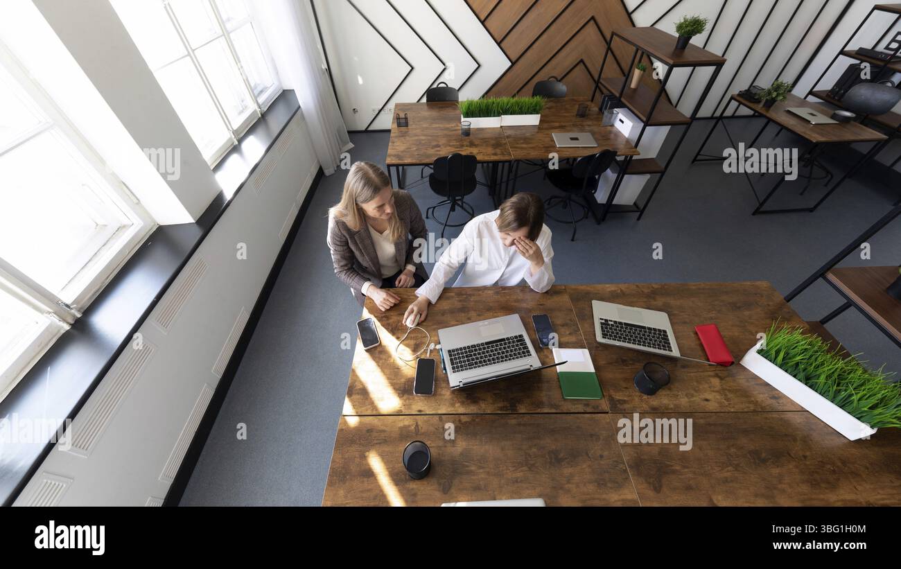 Two professionals engage in a work discussion, analyzing data on ...