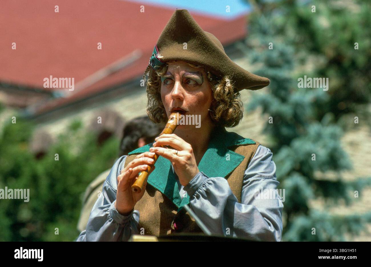 This image shows a musician in period clothing playing a recorder at ...