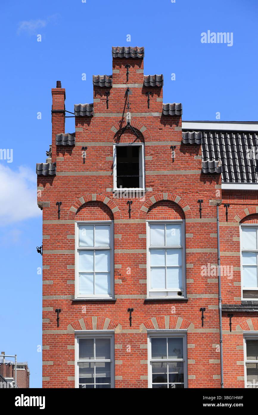 Old brick house facade with stepped gable and peculiar roof details in ...