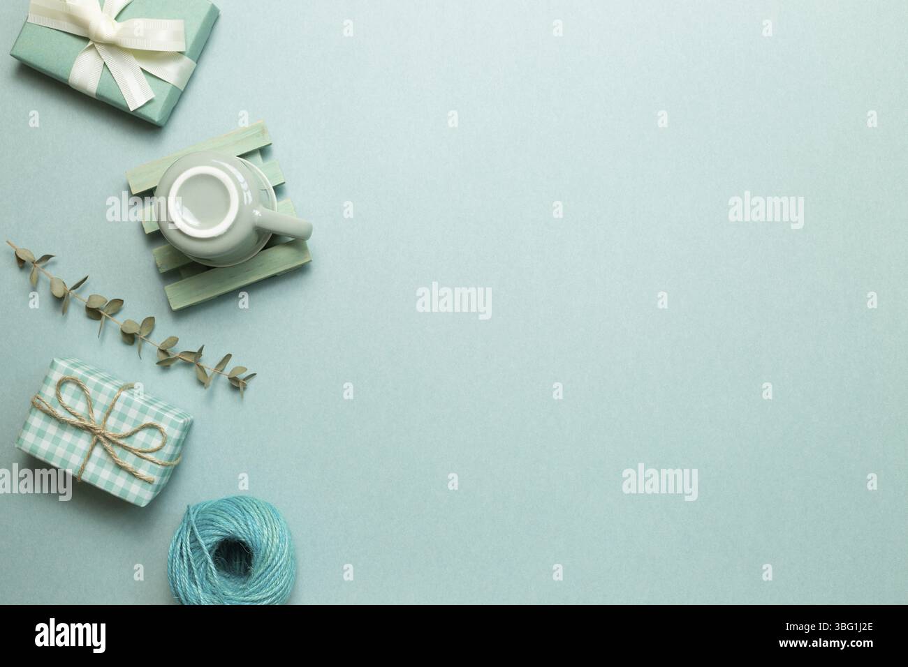 Gift boxes, coffee cup, string roll on mint green background. flat lay ...
