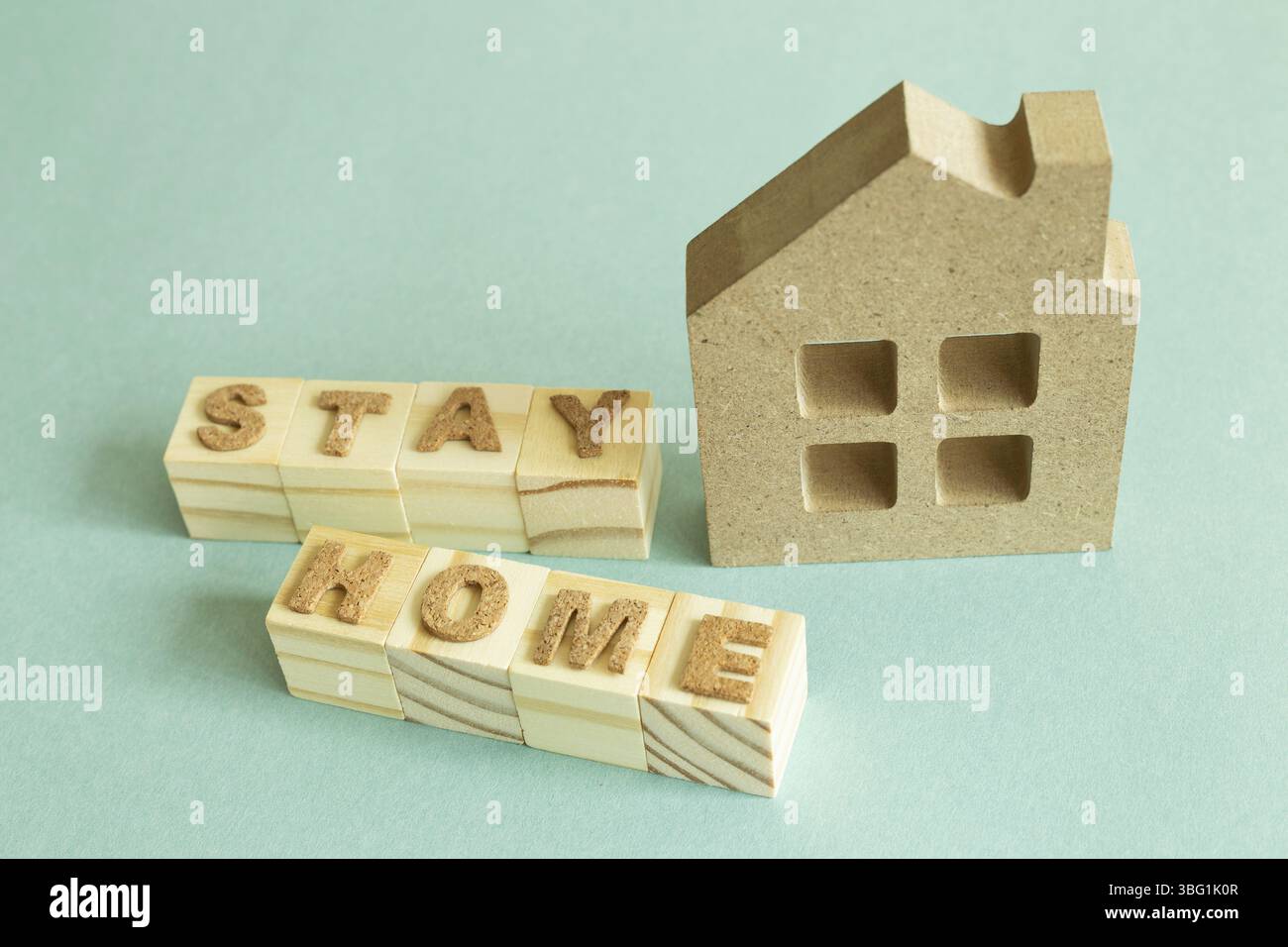 House model and word 'Stay Home' wooden blocks on green background ...