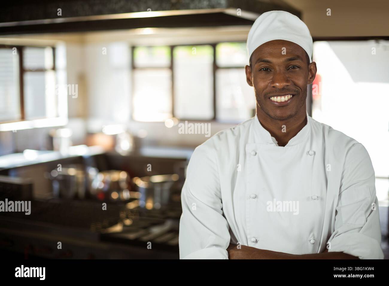 African American male chef in chef coat standing in restaurant kitchen ...