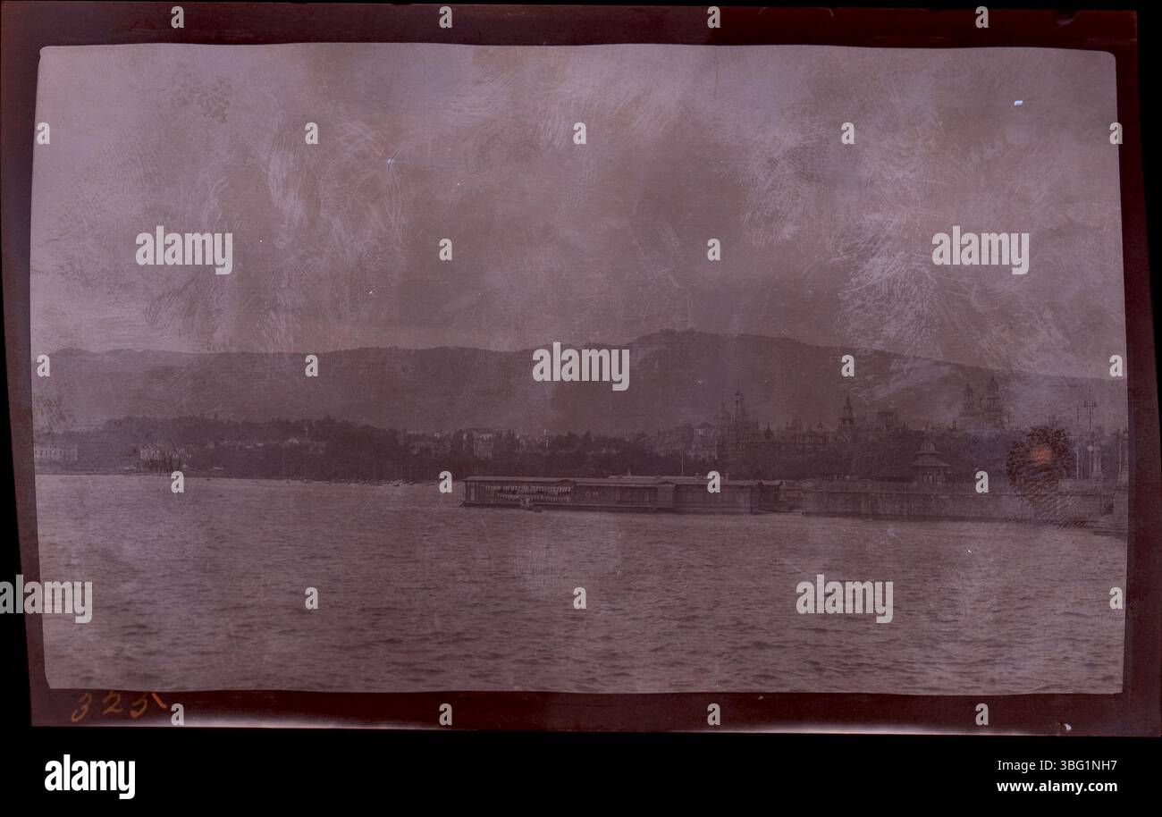 A view of Lake Zurich with mountains in the background and bathhouses ...