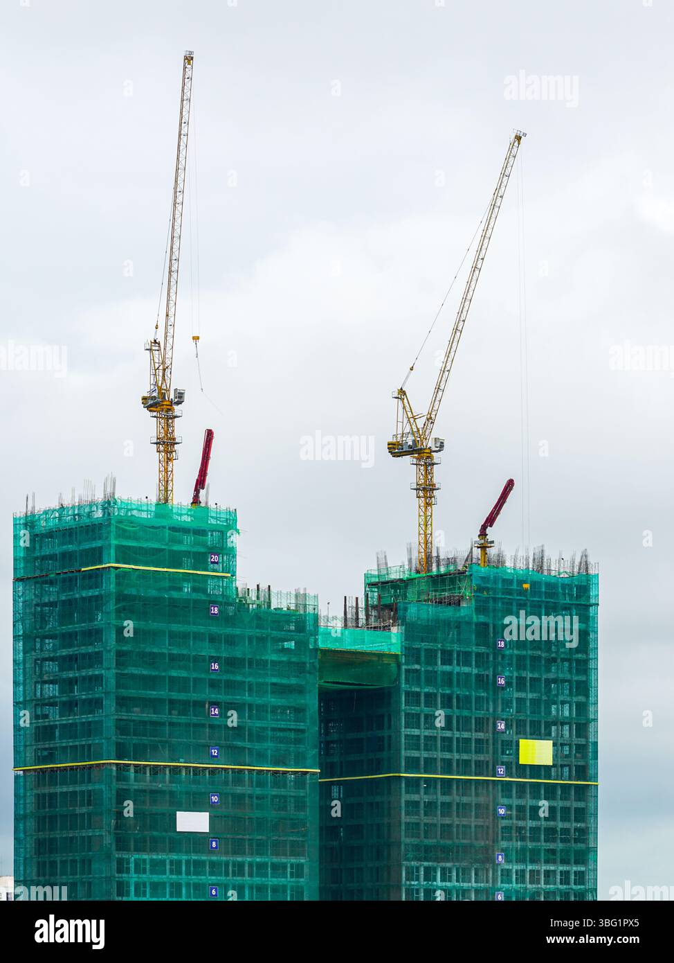 Twin Skyscraper Towers Under Construction with Green Mesh Safety ...