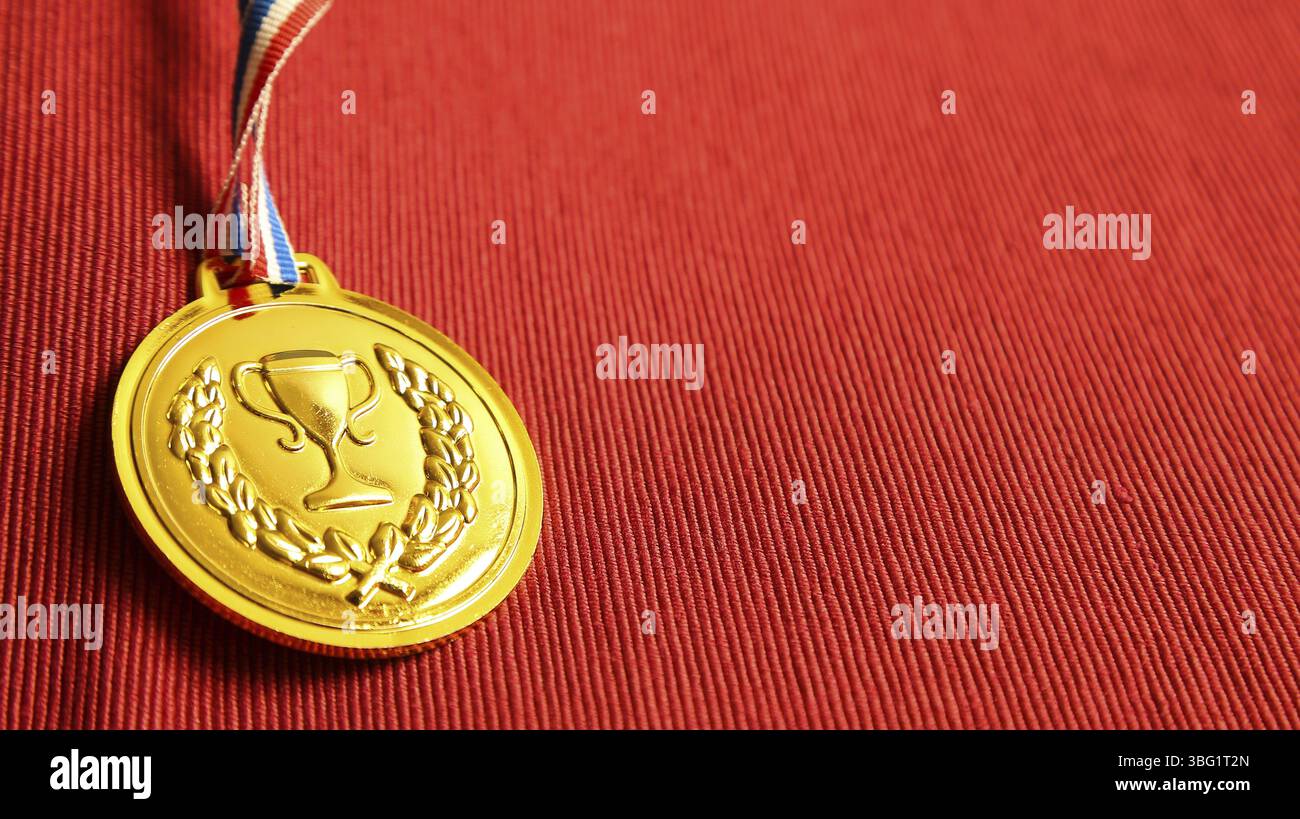 Gold medal on red background Stock Photo - Alamy