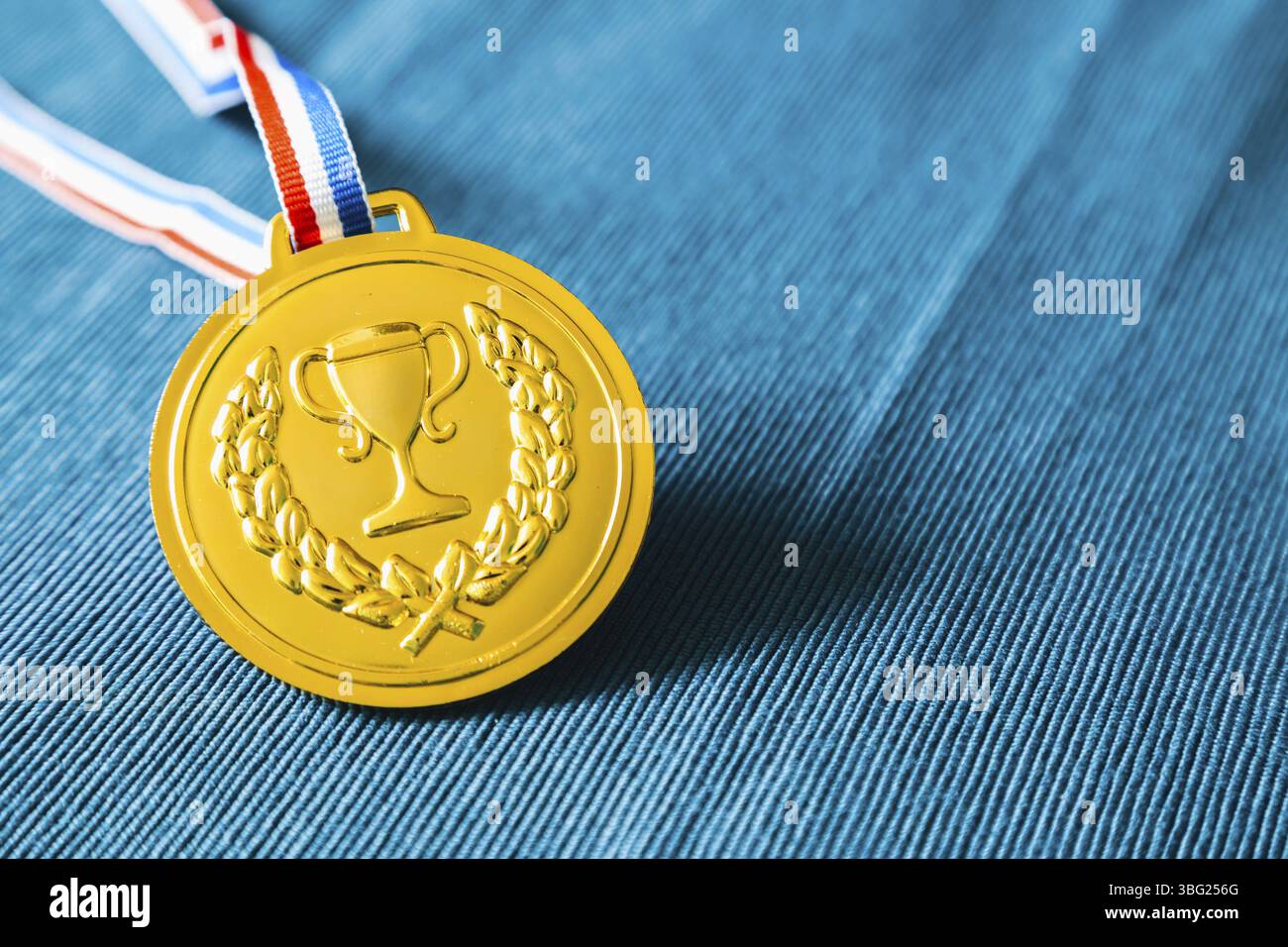 Gold medal on blue background Stock Photo - Alamy