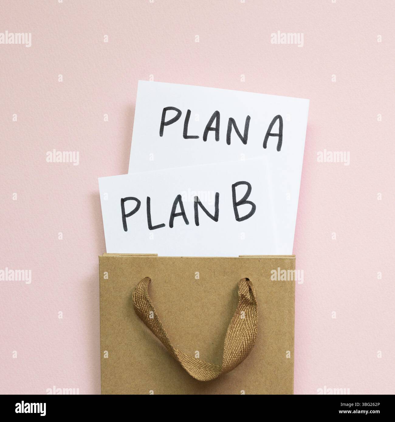 Plan A and plan B in a kraft paper bag on pink background. Business ...
