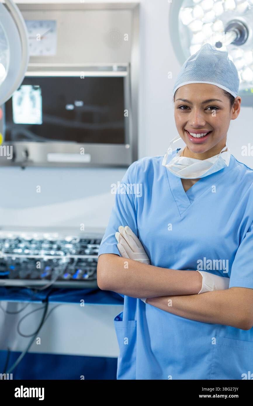 Female surgical nurse wearing scrubs and cap standing in operating room ...