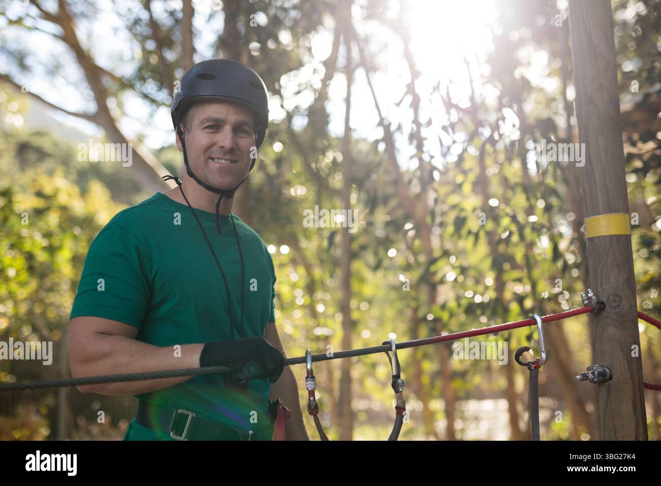 Man in thirties wearing safety helmet and gloves holding cable on ...