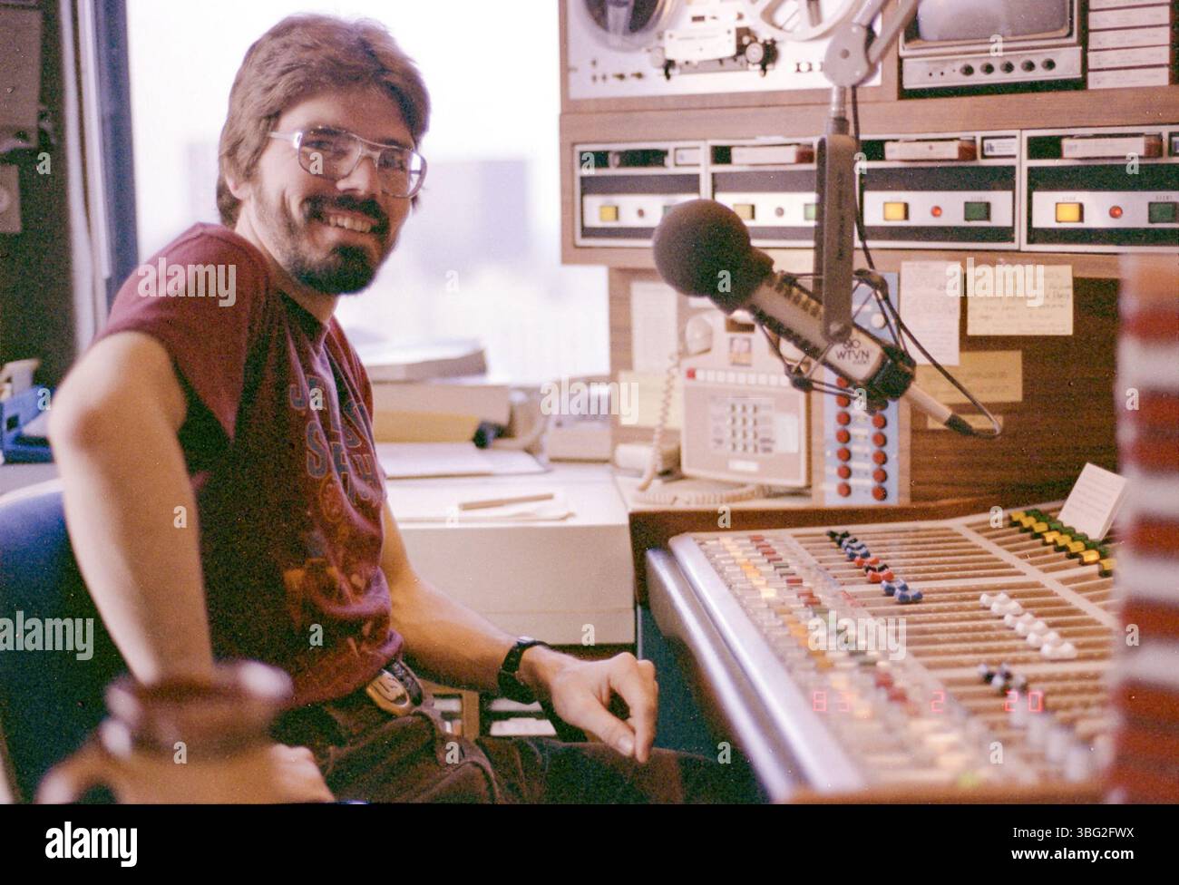 DJ Michael Ossing is shown posing for a picture in front of the board ...