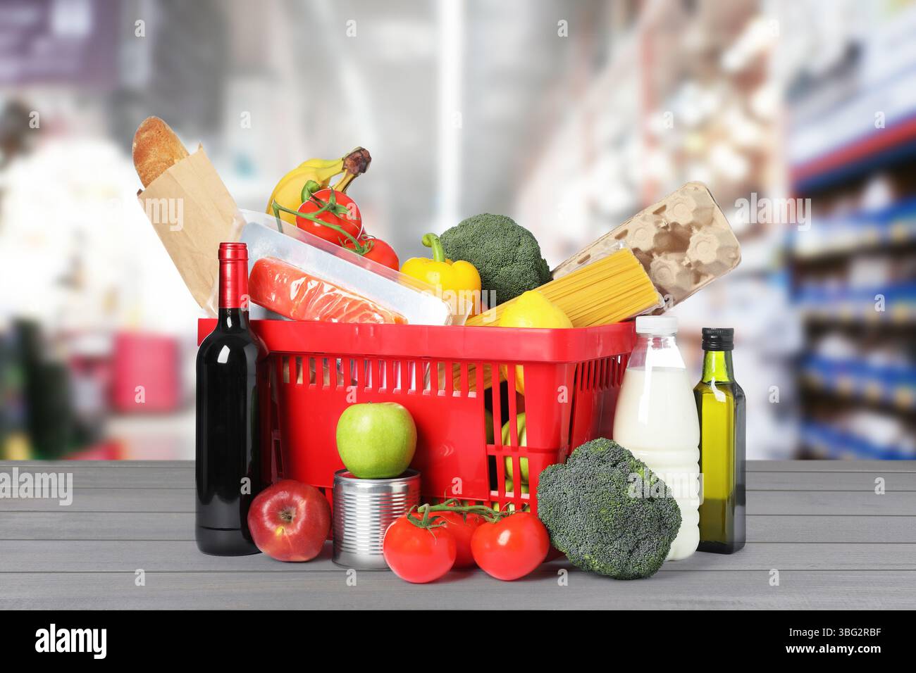 Red shopping basket with groceries on wooden table in supermarket Stock ...