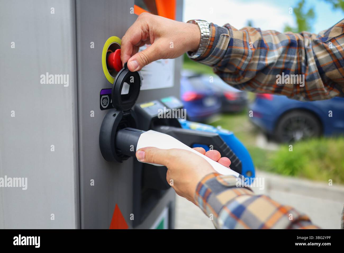 Man charging electric car at EV station. Eco-friendly transportation ...