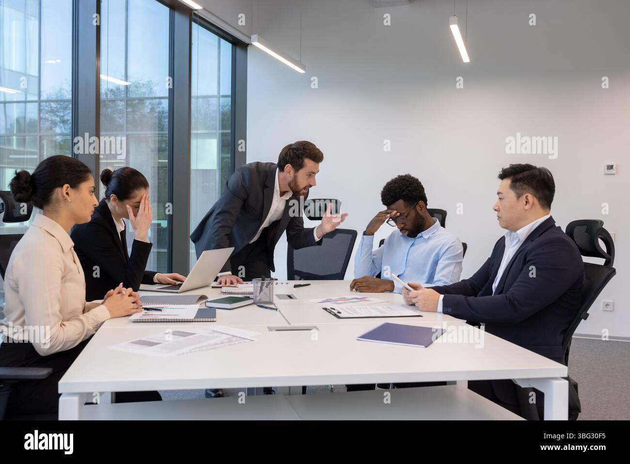A tense business meeting shows signs of frustration and disagreement ...
