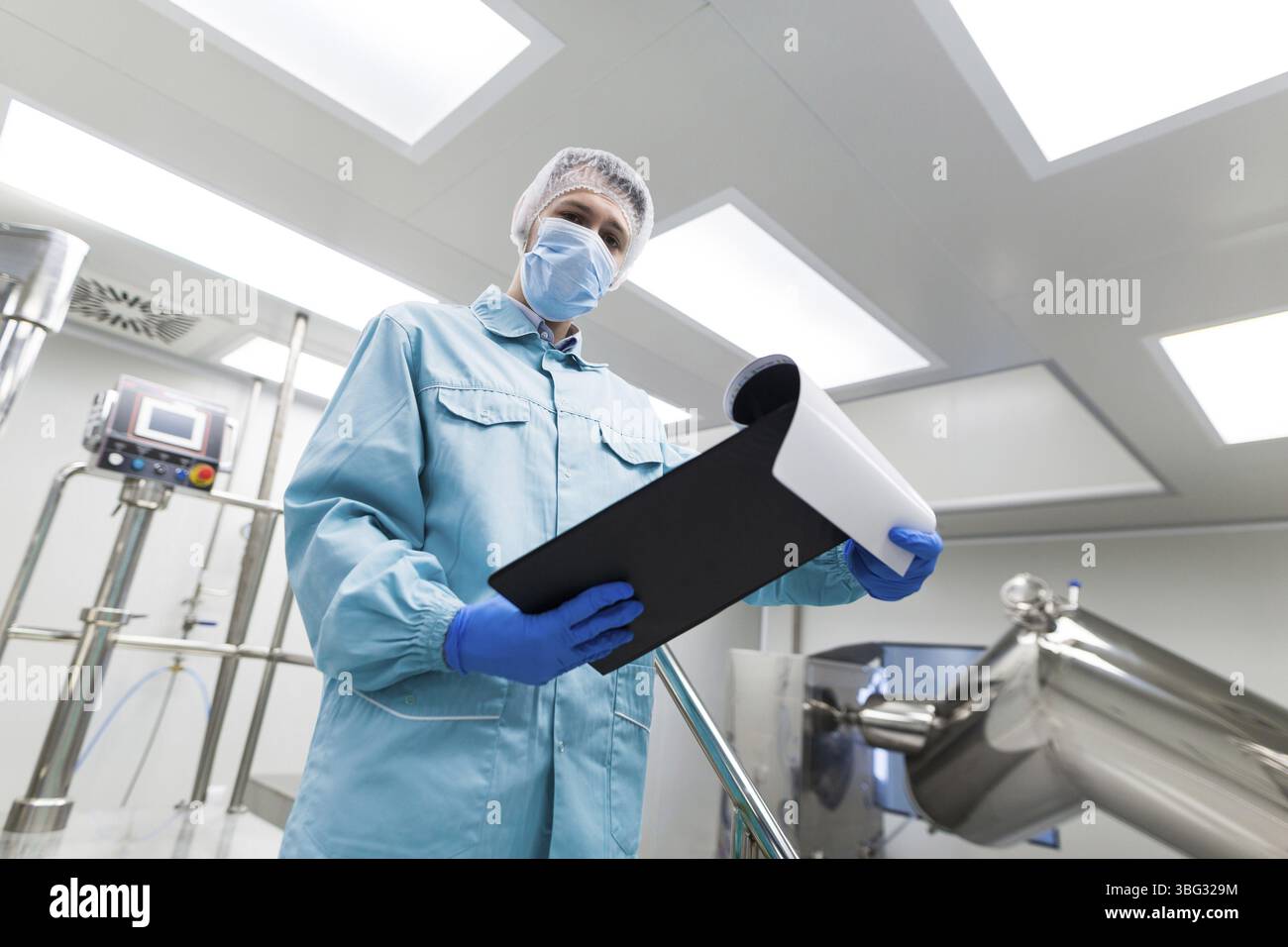 Close look of scientist in blue lab suit stand on metal chromed stairs ...