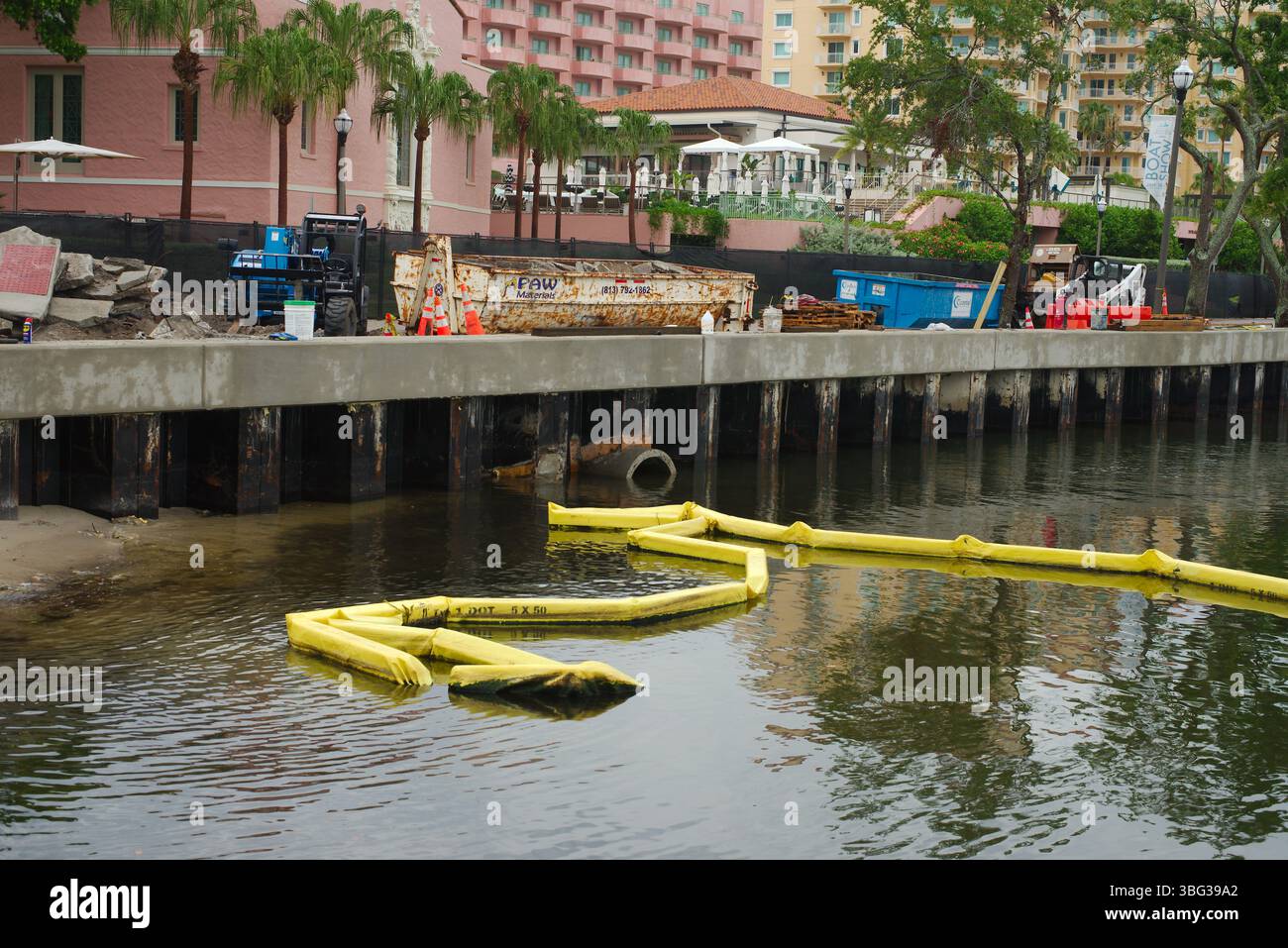 Calm urban waterfront showing a yellow floating barrier by the dock ...