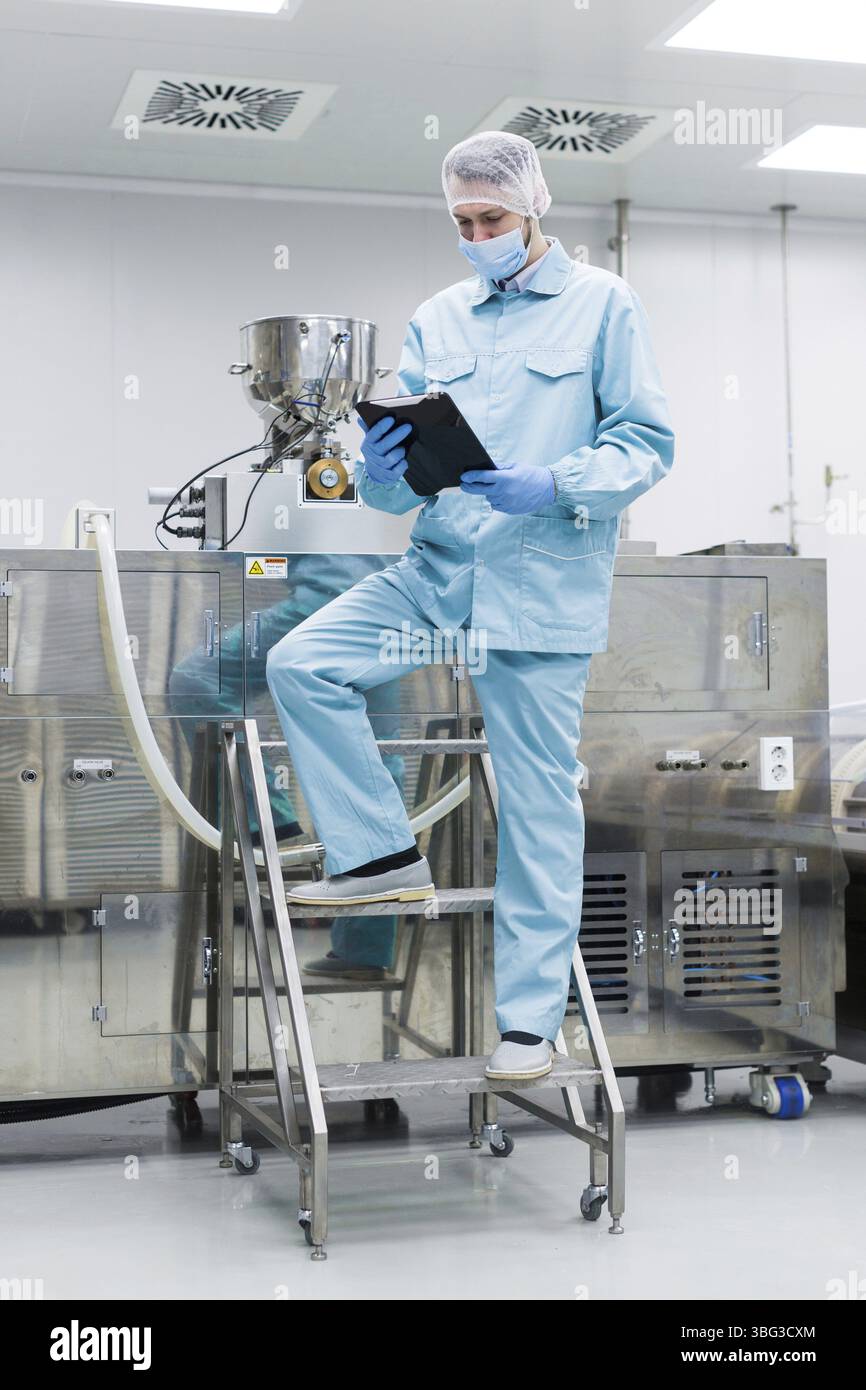 Vertical picture, caucasian scientist man in blue lab suit work with ...