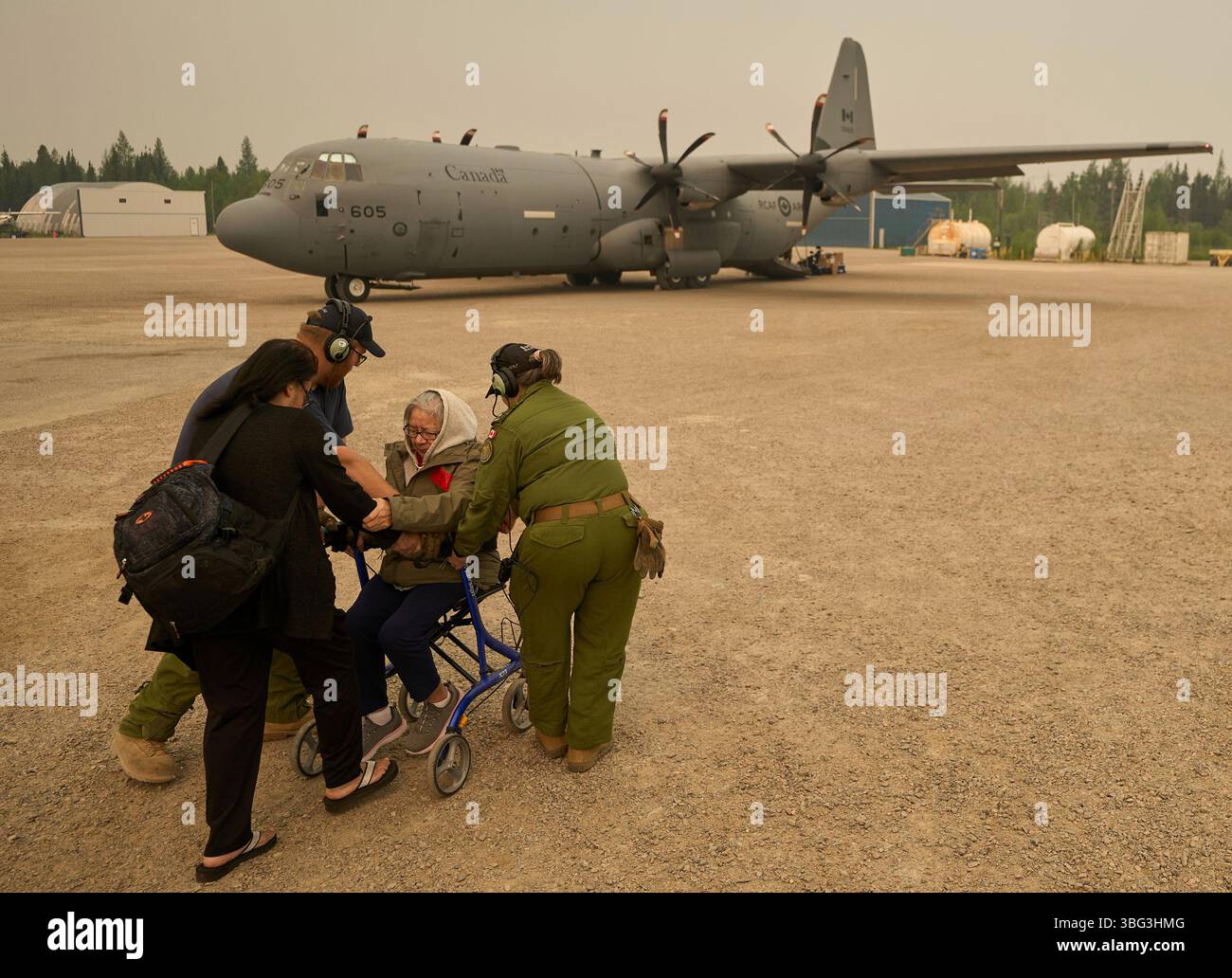 Members of the Royal Canadian Air Force help evacuate Abbie Duskun (seated) and her daughter ...