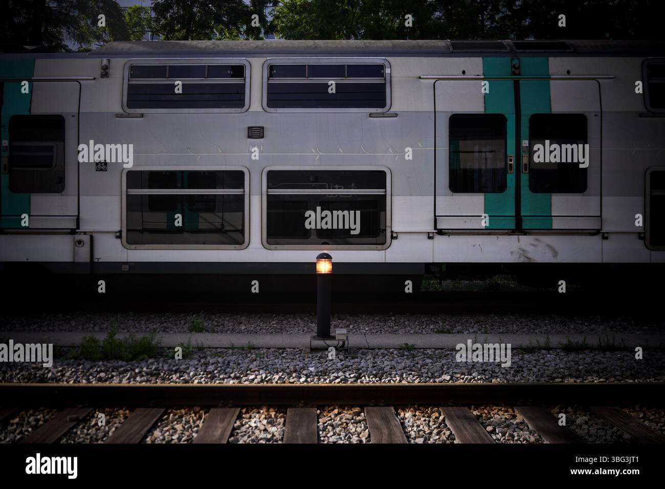 French suburban train behind illuminated track bollard Stock Photo - Alamy