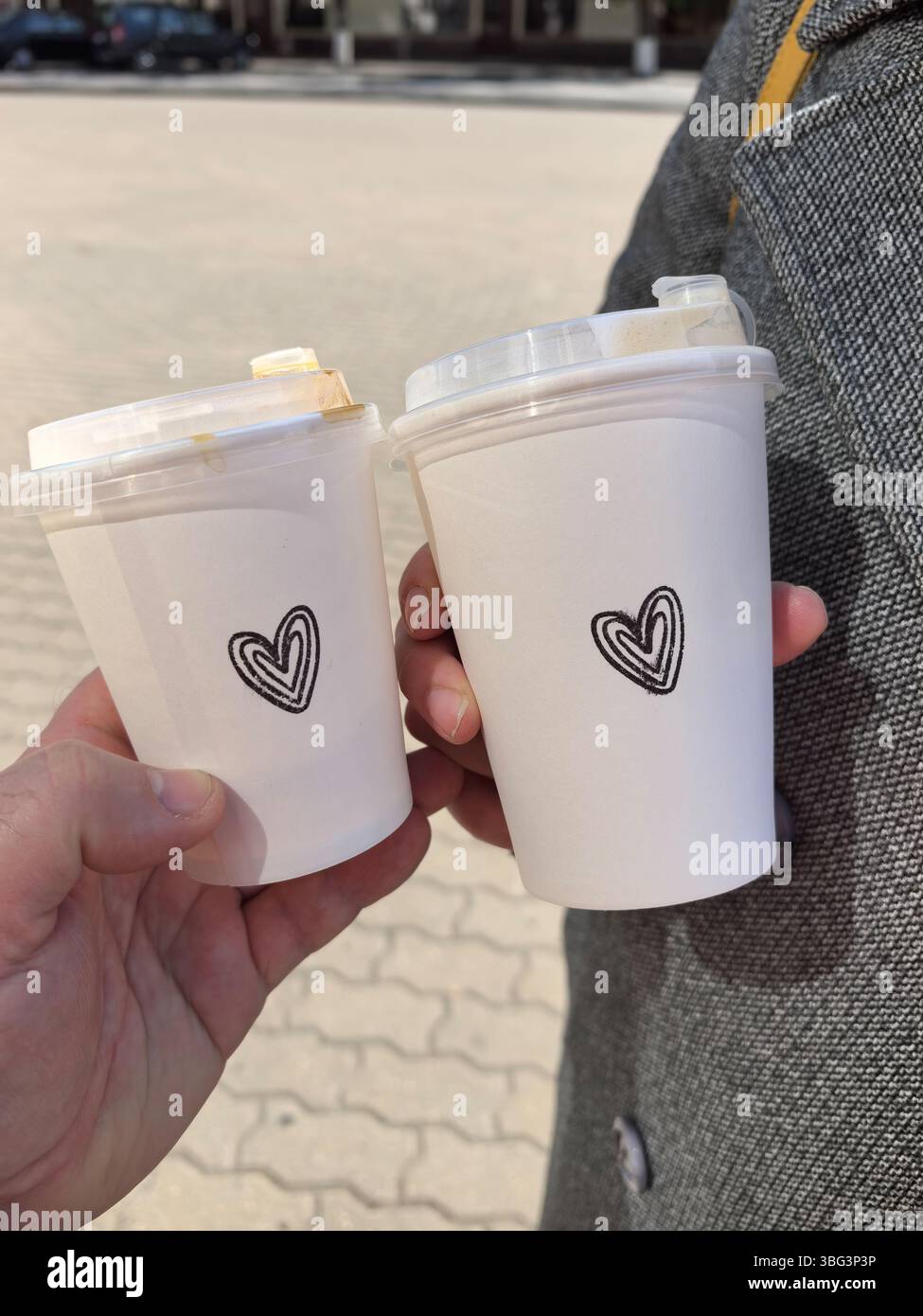 Two hands hold cups hi-res stock photography and images - Alamy