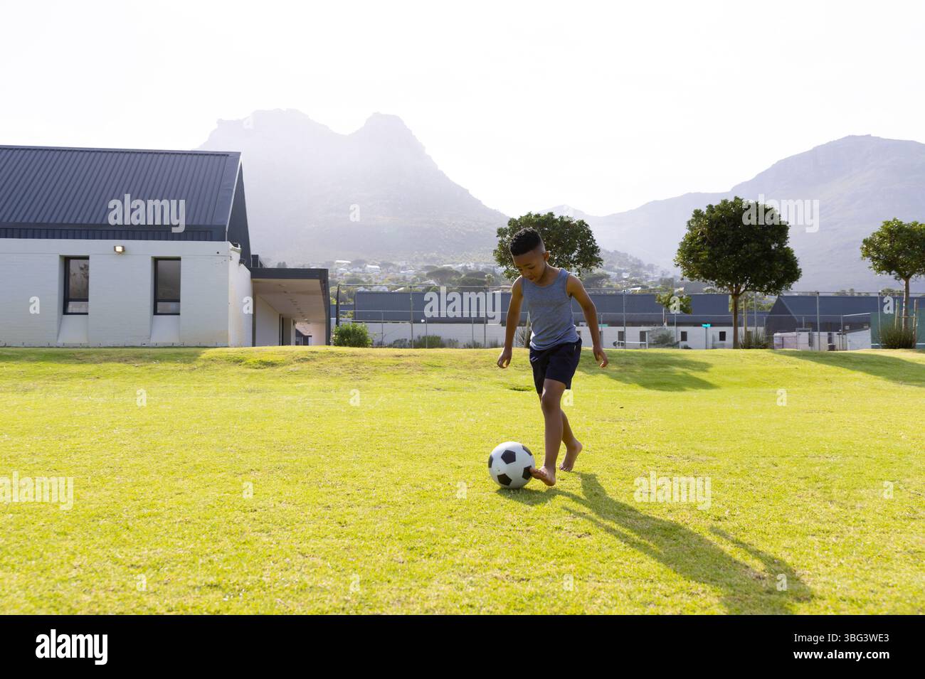 Barefoot boy kicking soccer ball hi-res stock photography and images ...