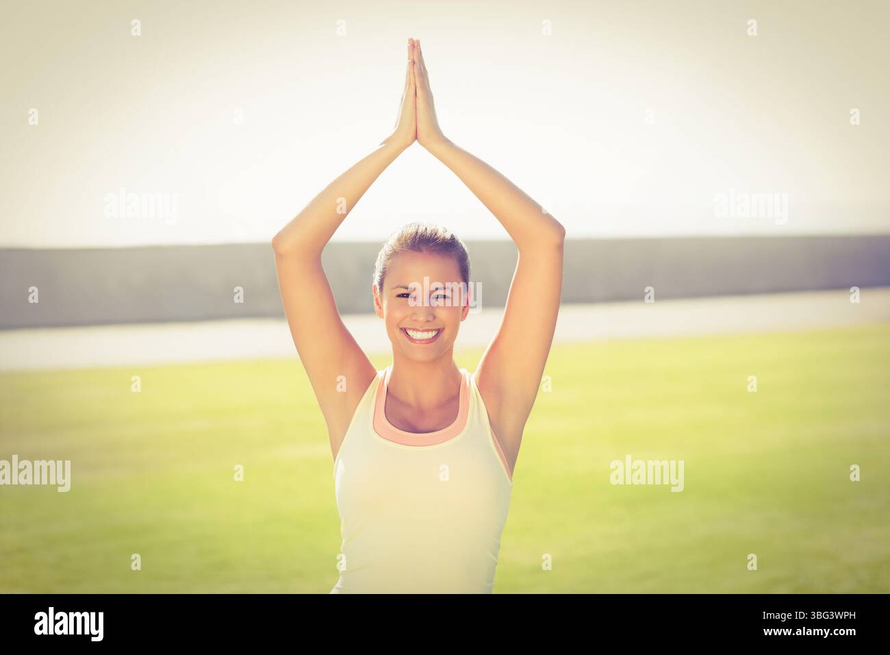 Female in her thirties in sportswear stretching into yoga prayer pose ...