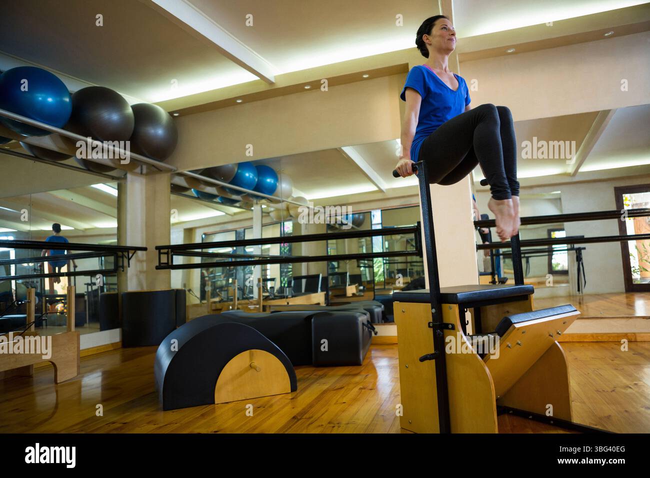 Pilates chair standing on floor in Pilates studio with mirrored walls ...