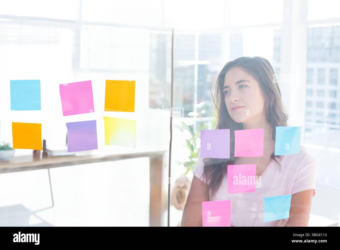 Female professional standing by glass panel covered with colorful ...