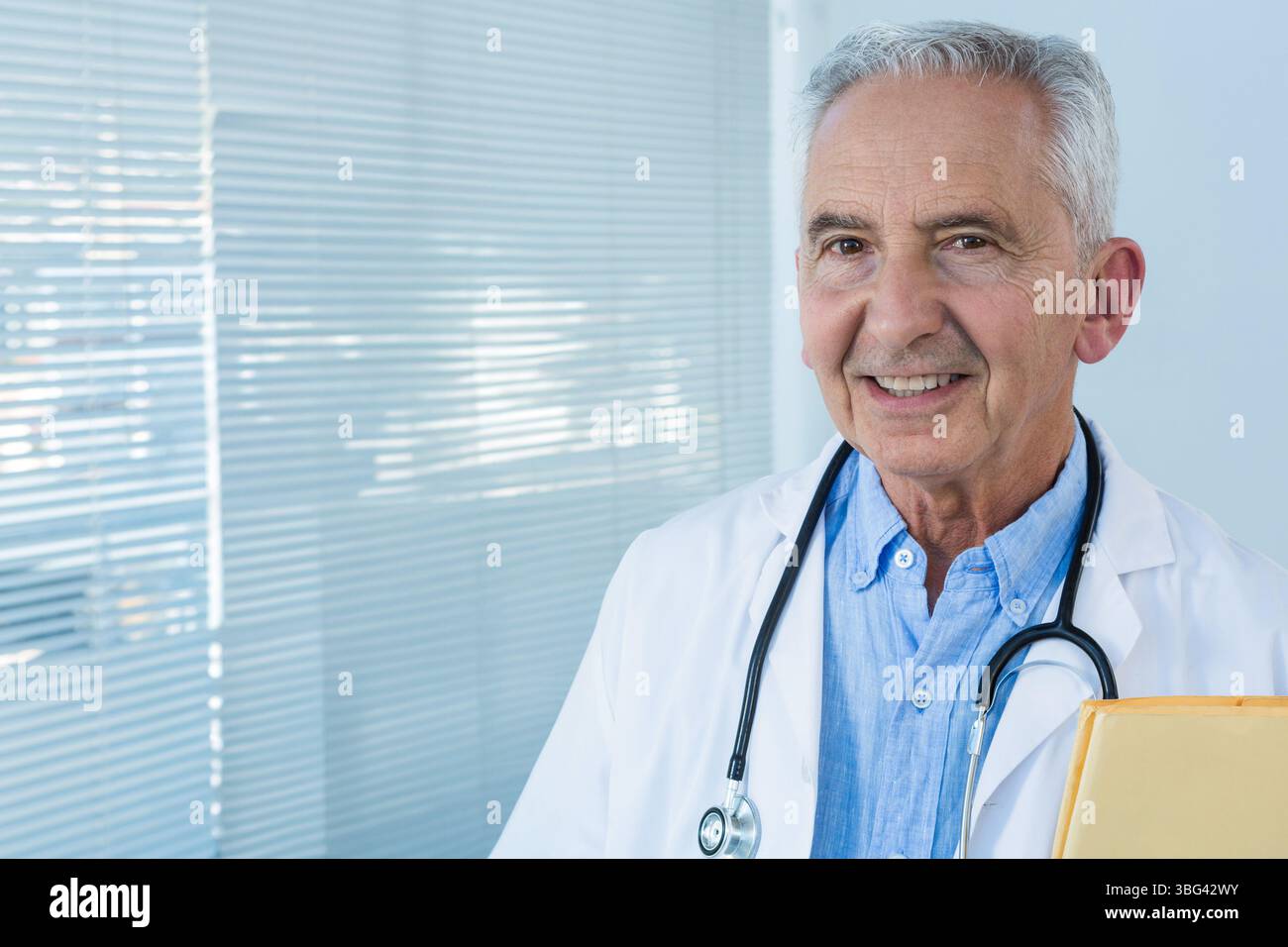 Senior doctor wearing white coat holding folder and stethoscope at ...