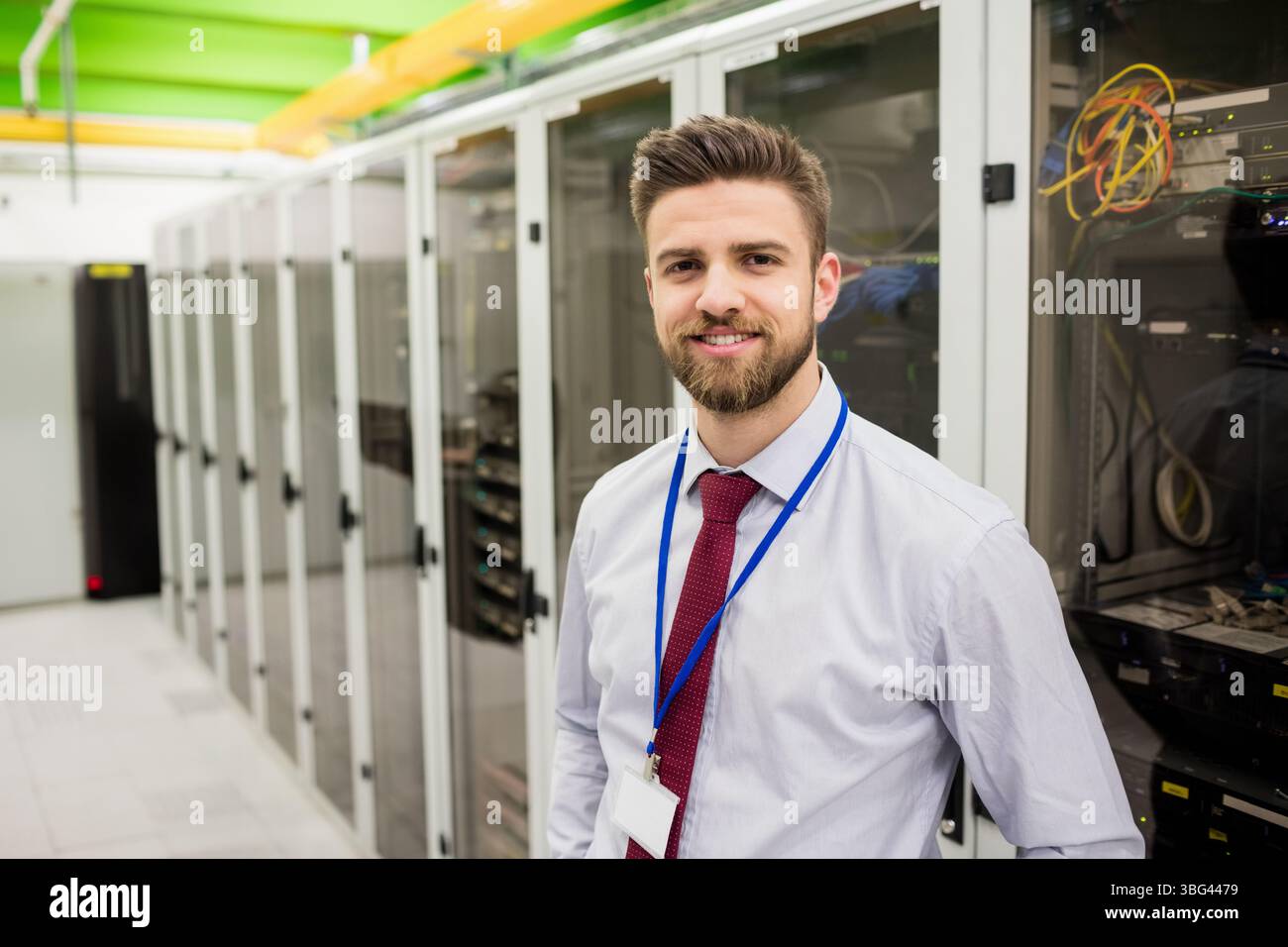 Male IT professional wearing light shirt, red tie inspecting server ...